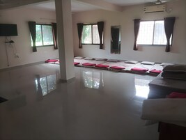 Quarto de hotel com cama grande, televisão de tela plana na parede e ventilador de teto.
