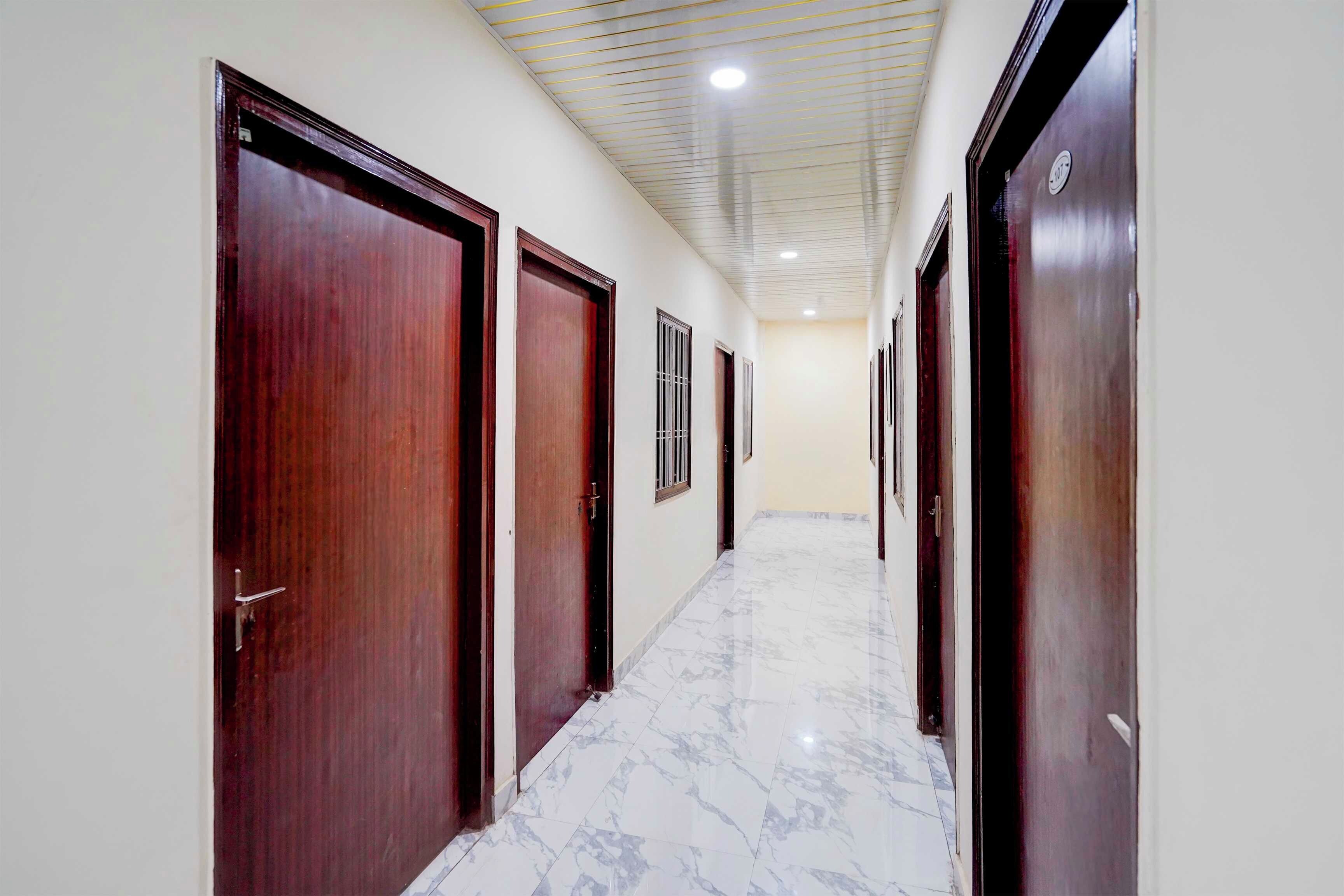 Um corredor com portas de madeira e chão de azulejos.