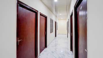 Um corredor com portas de madeira e chão de azulejos.