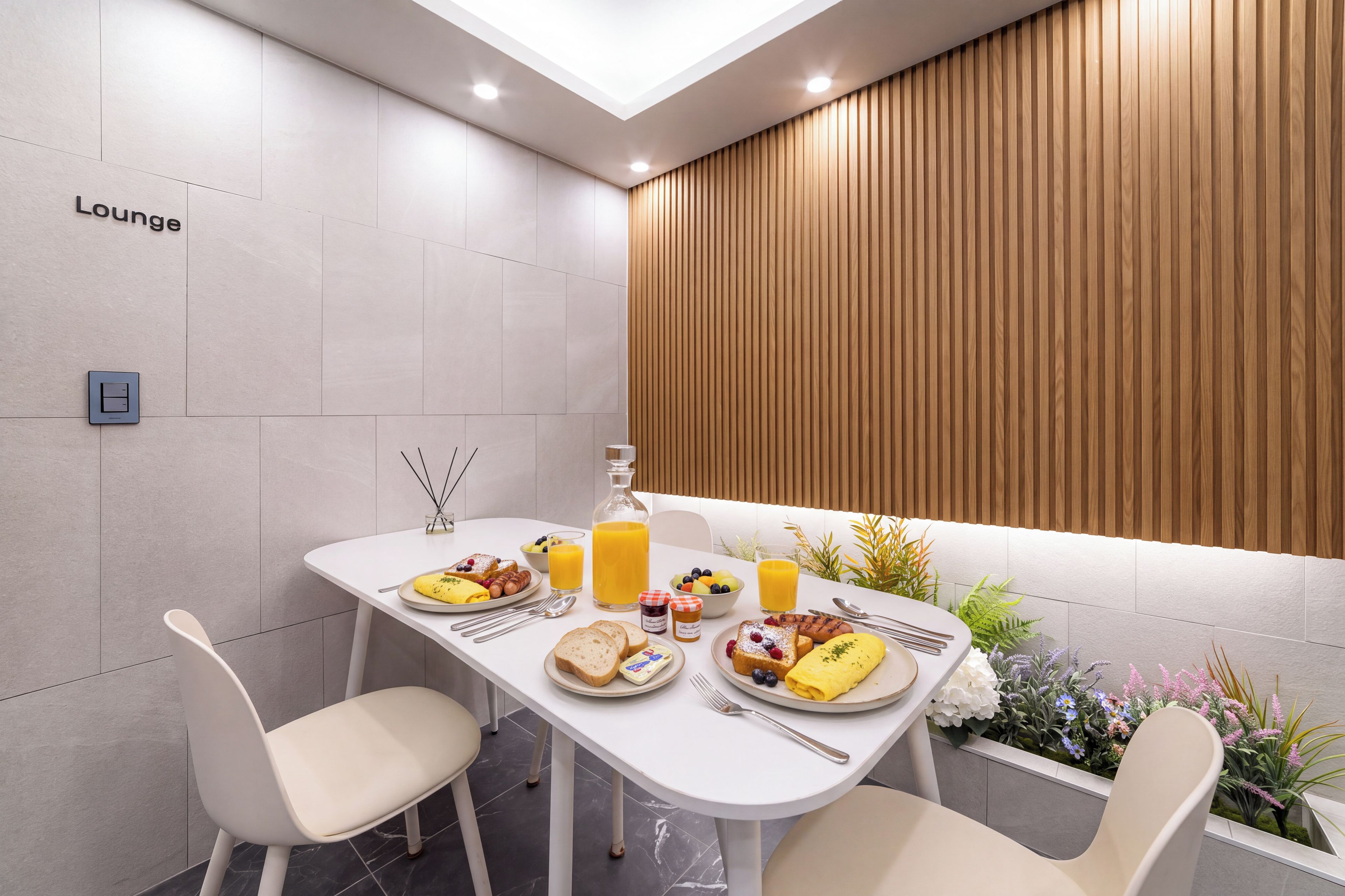 Um lounge moderno com uma mesa branca posta para o café da manhã, incluindo torradas, ovos e frutas.