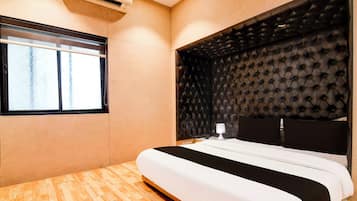 Um quarto moderno com uma cama grande, uma janela e um ar condicionado fixado na parede.