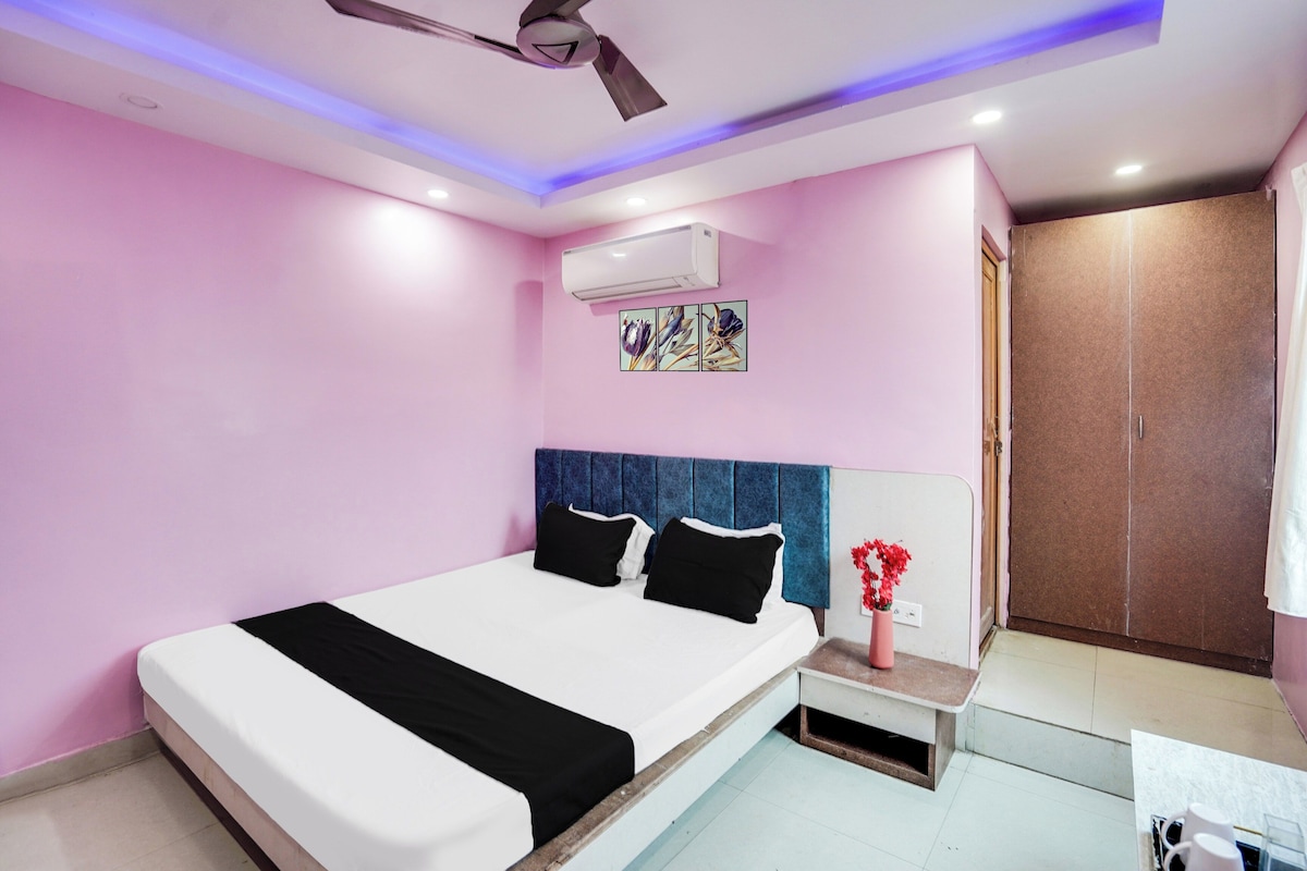 Quarto de hotel com cama, mesa de cabeceira e ar condicionado.