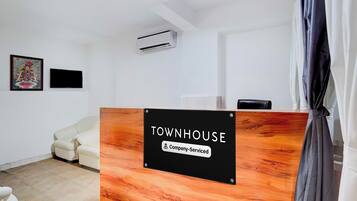 Uma mesa de recepção com uma placa indicando que se trata de uma casa geminada com serviços da empresa.