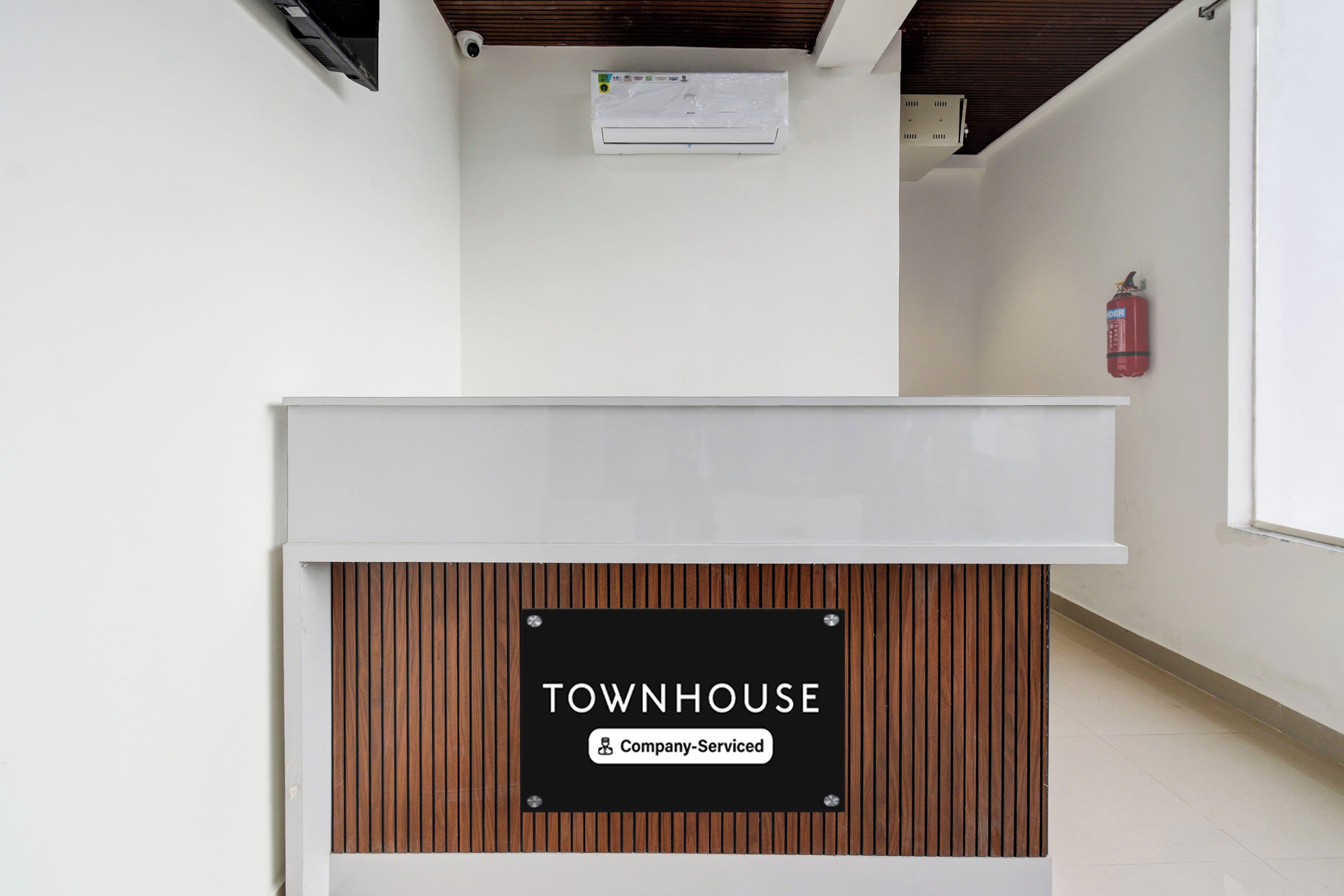 Uma mesa de recepção com uma placa que diz 'TOWNHOUSE Company Serviced'.