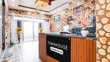 Uma área de recepção com uma placa indicando 'TOWNHOUSE Company-Serviced'.