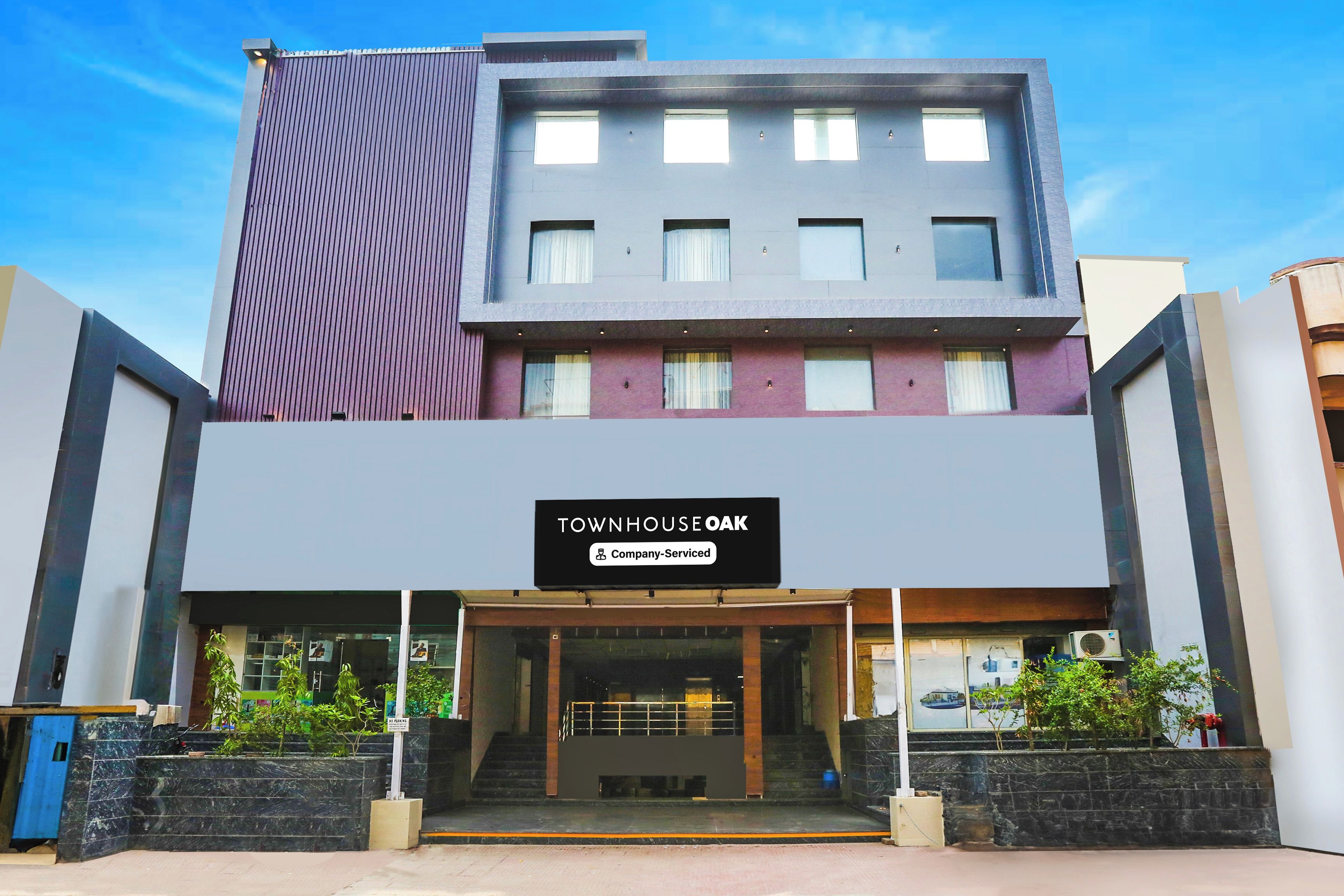 Um edifício moderno com uma placa que diz 'TOWNHOUSE OAK Company Serviced'.