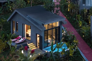 Uma casa moderna com piscina, portas de vidro e um caminho vermelho.