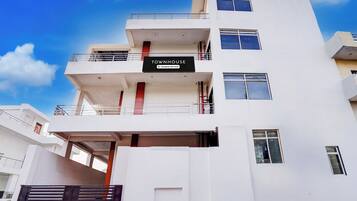 Edifício de vários andares com placa indicando que é uma casa urbana com serviços para empresas.
