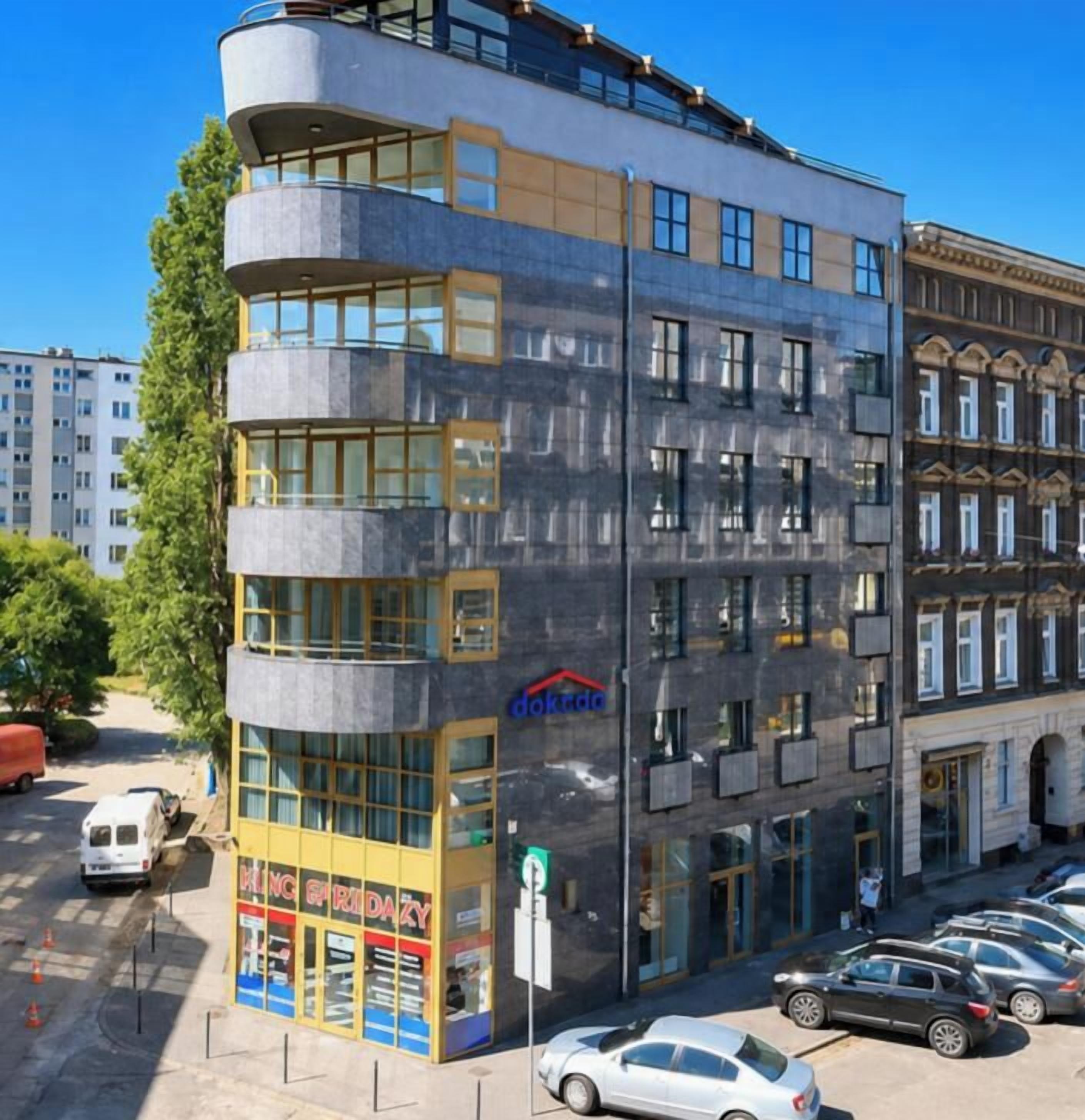 Edifício de vários andares com design moderno, apresentando um espaço comercial no térreo com vitrine aparente.