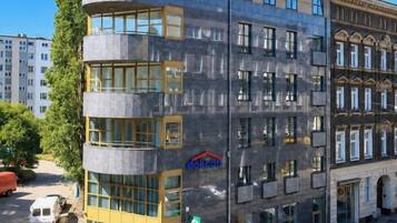 Edifício de vários andares com design moderno, apresentando um espaço comercial no térreo com vitrine aparente.
