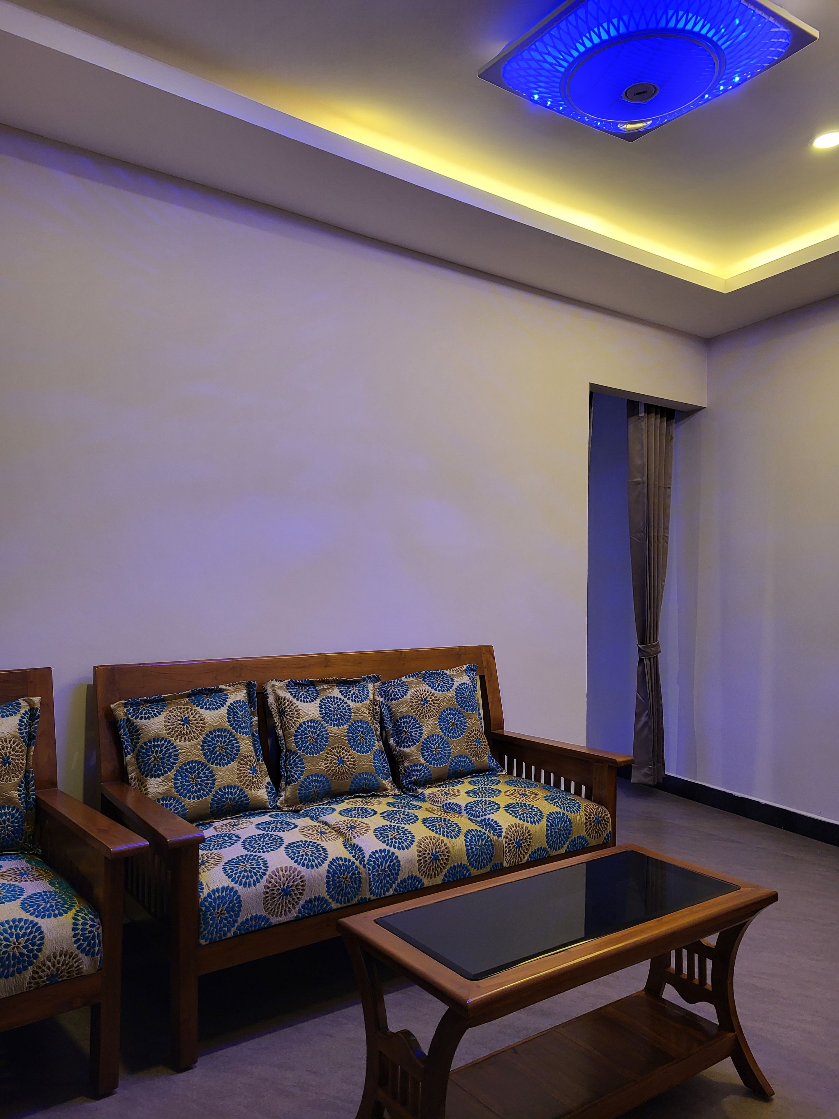 Uma sala de estar moderna com um conjunto de sofá e uma mesa de centro de vidro.