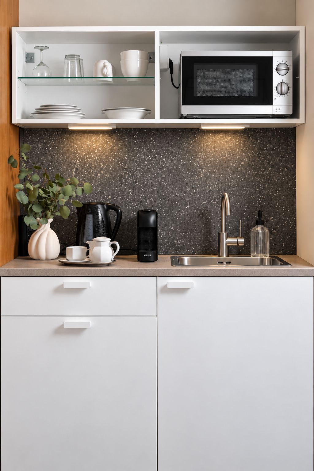 Cozinha equipada com micro-ondas, cafeteira e pia.