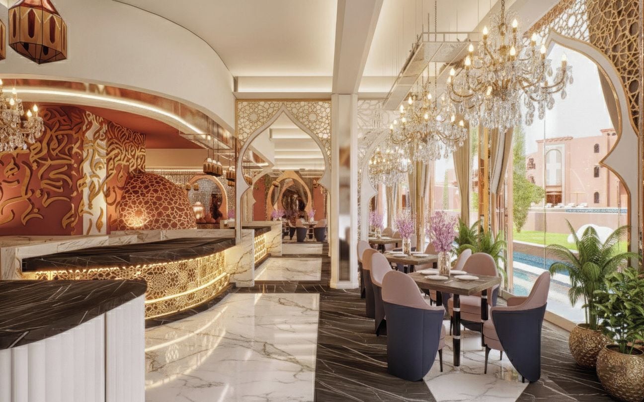 Um hall de hotel luxuoso com piso de mármore, detalhes elaborados nas paredes e área de estar com cadeiras modernas.