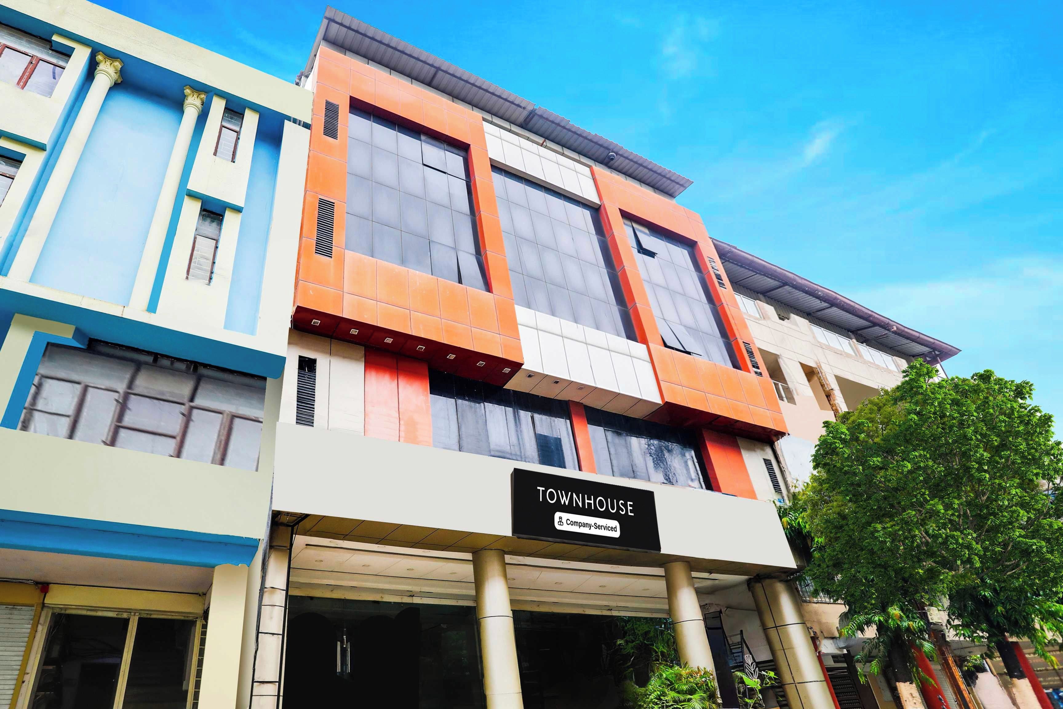 Um edifício com vários andares com uma placa indicando que se trata de uma casa geminada com serviços para empresas.