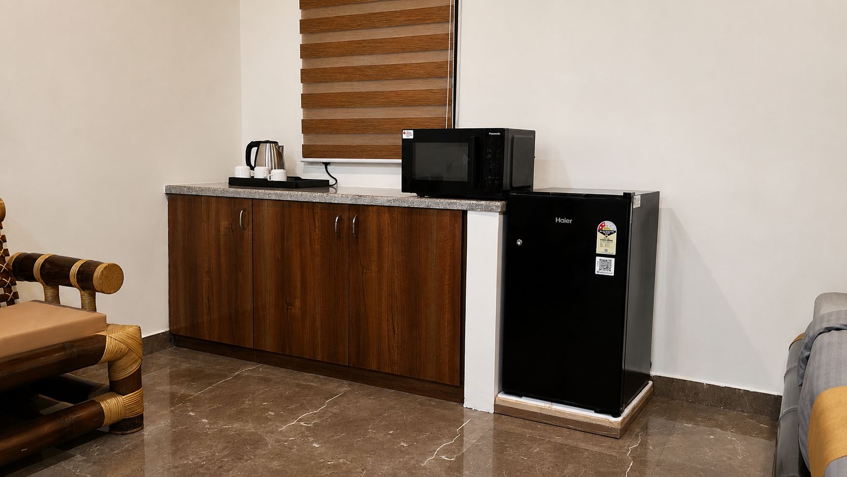 Cozinha compacta com micro-ondas, geladeira e cafeteira no balcão.