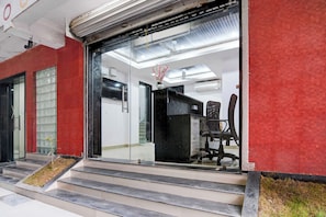 Interior de escritório moderno, com balcão de recepção, cadeiras de escritório e escada que leva à entrada.