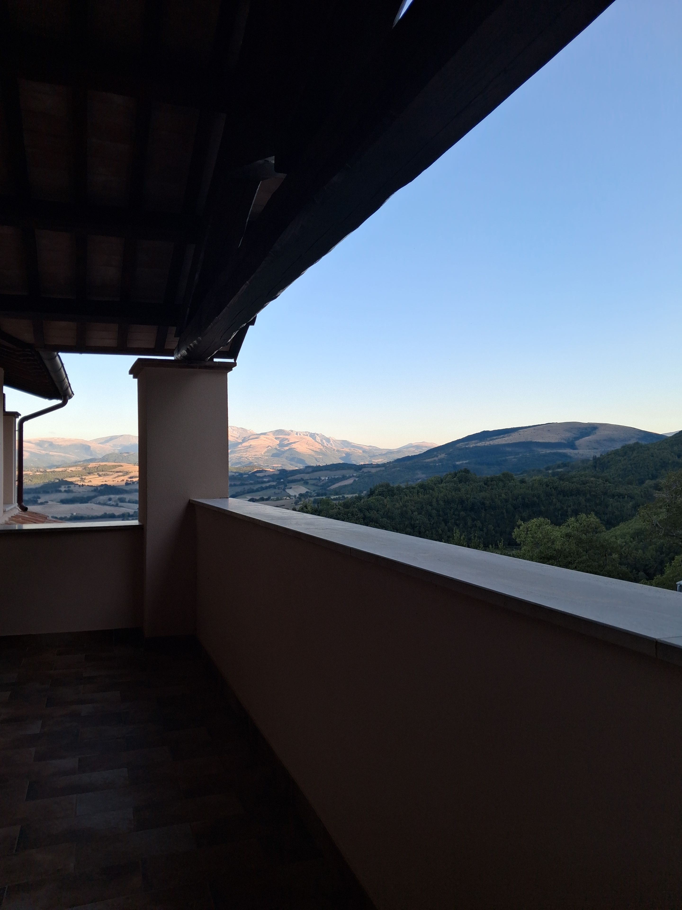 Varanda com vista para uma paisagem montanhosa.