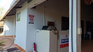 Uma área de recepção com uma placa indicando ser uma zona isenta de fumo e uma placa com a inscrição 'RECEPCION', sugerindo um balcão de atendimento.