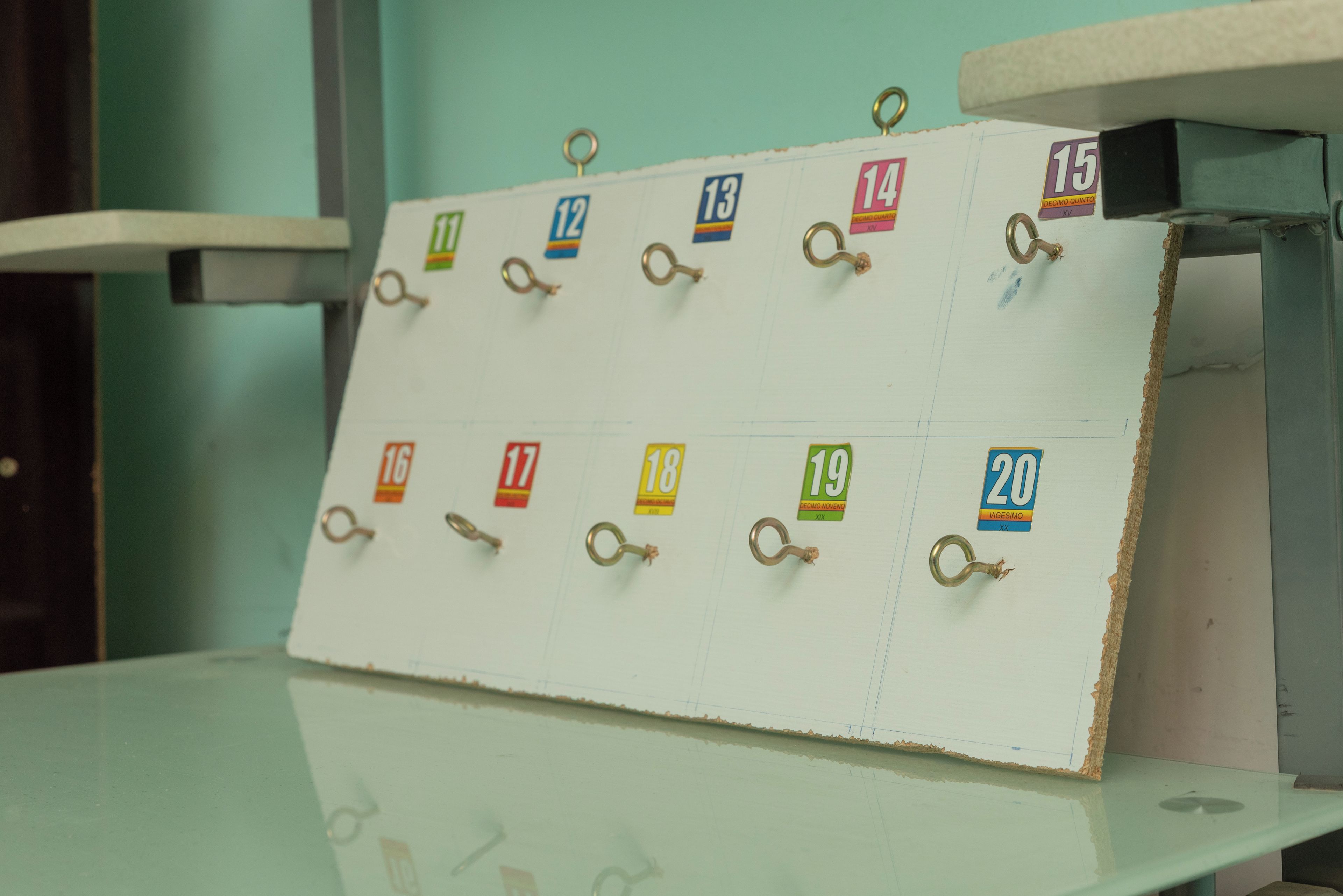 Um calendário fixado na parede com espaços numerados, cada um com um aro metálico.