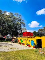 Um edifício com fachada amarela, telhado vermelho e porta preta.