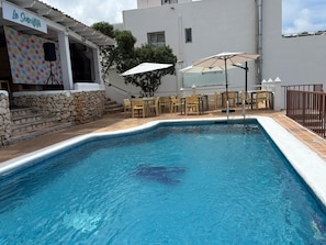 Uma piscina com um muro de pedra e uma placa com a inscrição 'La Sencilla'.