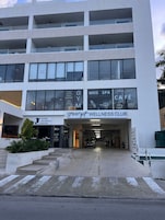 Edifício de vários andares com clube de bem-estar, academia, spa e café.