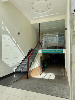 Uma escadaria com guarda-corpo de vidro que dá para um patamar.