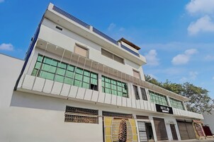 Um hotel de vários andares com fachada moderna, grandes janelas e um letreiro chamativo com a palavra 'HOTEL'.