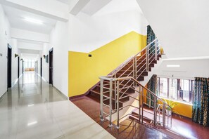 Corredor de hotel com escada que dá para uma varanda.