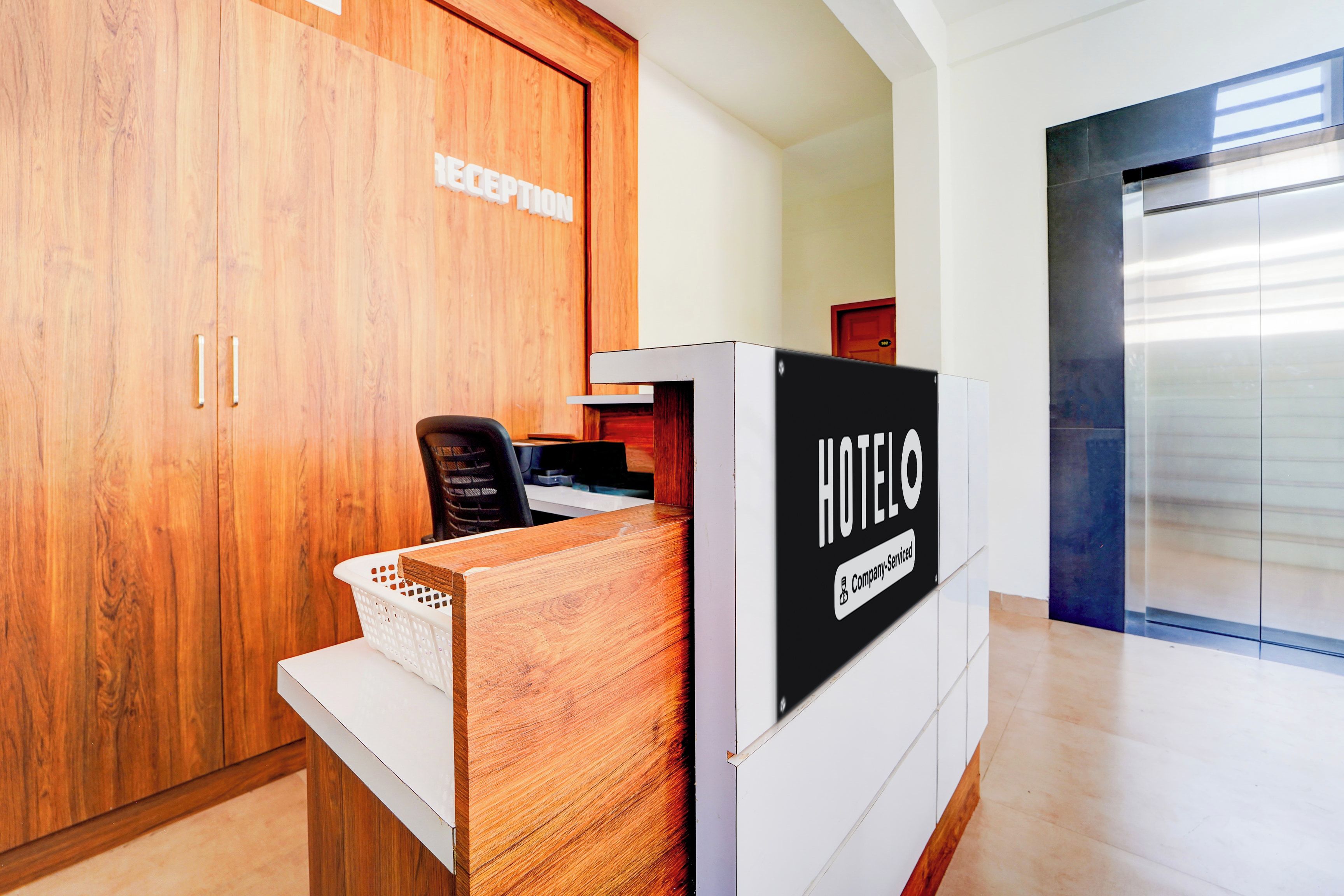 Balcão de atendimento com placa indicando ser um hotel de serviço empresarial.