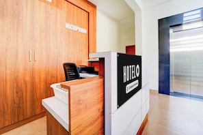 Balcão de atendimento com placa indicando ser um hotel de serviço empresarial.