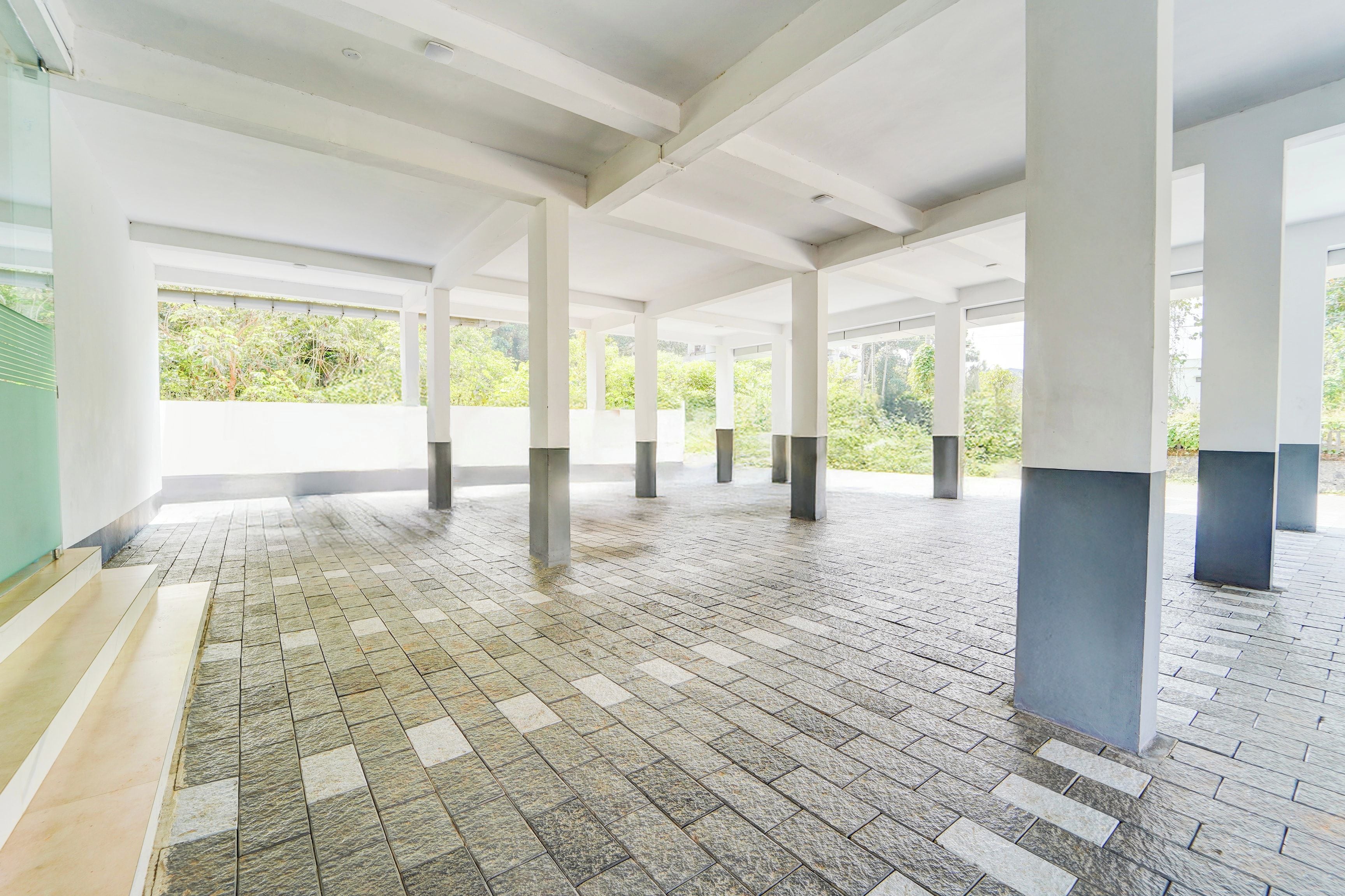 Amplo espaço interno com piso ladrilhado e várias colunas sustentando o teto.