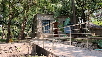 Um edifício de pedra com escadaria de metal que leva a uma porta de madeira.