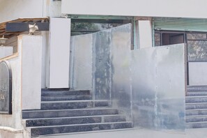 Entrada de um edifício com um conjunto de degraus que levam a uma porta.