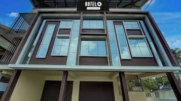 Edifício moderno de hotel com placa indicando serviço corporativo.
