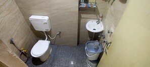 Casa de banho pequena com sanita, lavatório e dispensador de água.