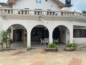 Um edifício com um pátio coberto, apresentando uma série de arcos e piso de azulejos.
