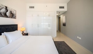Quarto com cama, mesa de cabeceira, guarda-roupa e uma obra de arte na parede.