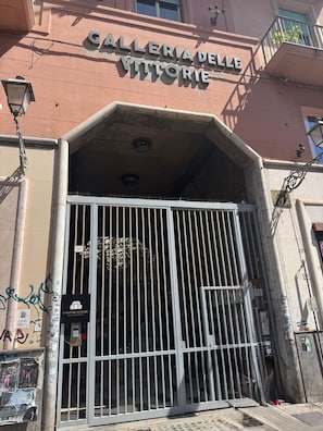 Uma entrada com portão para um edifício, com uma placa que diz 'Galleria delle Vittorie'.