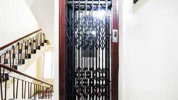 Uma escadaria com um portão de metal no topo.