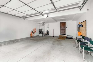 Um espaço amplo e interno, com teto alto, uma porta e um banco com uma placa.