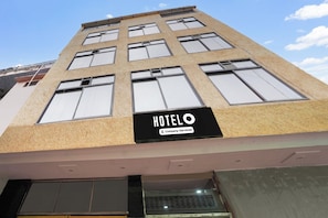 Um edifício com várias janelas e uma placa com a inscrição 'HOTEL Company-Serviced'.