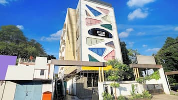 Um hotel moderno com fachada geométrica única e placa indicando que é um hotel de serviço corporativo.