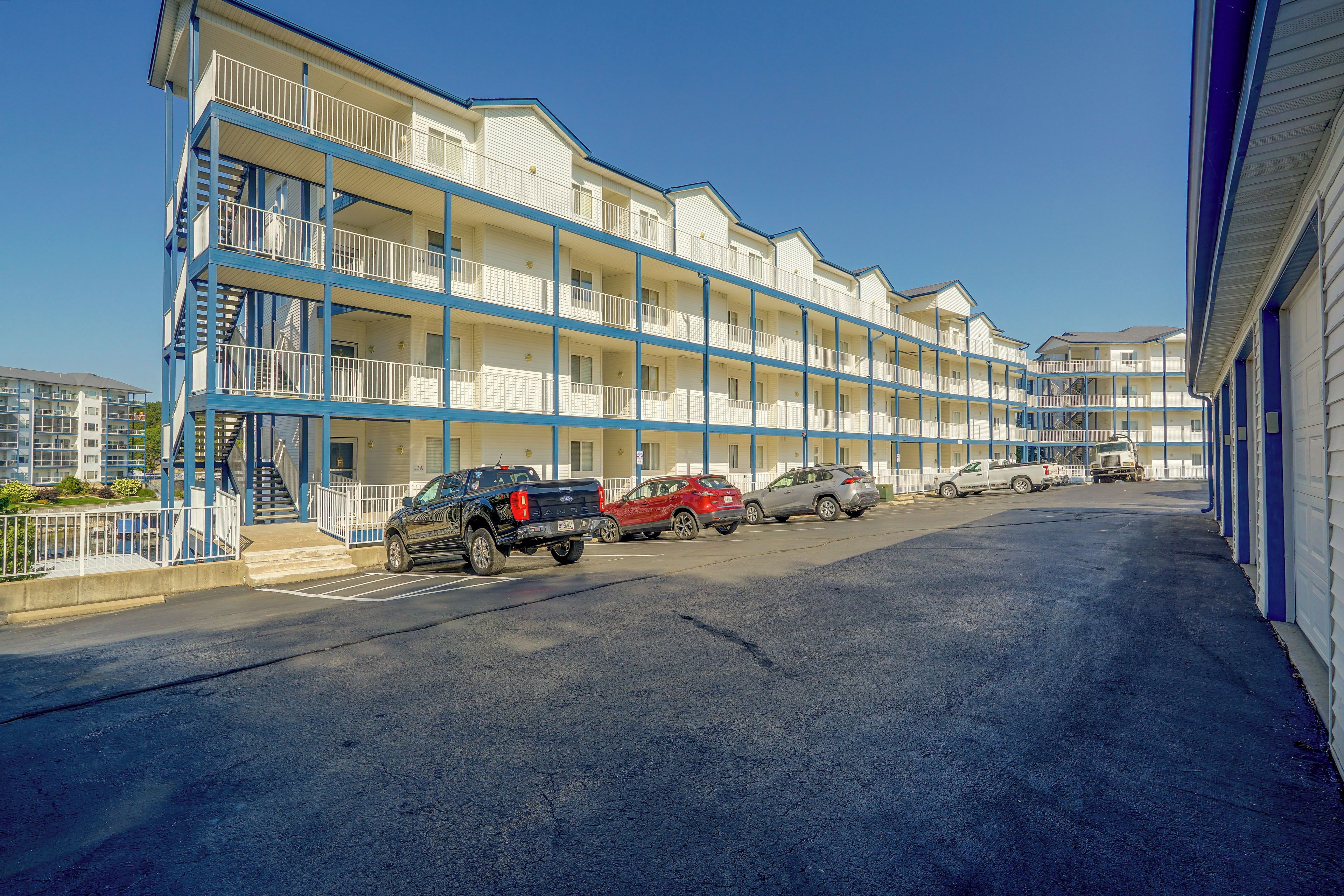 Um motel com vários andares e área de estacionamento na frente.