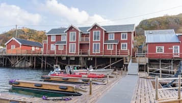 Imóvel à beira-mar com um cais, um edifício vermelho com várias janelas e uma construção vermelha menor.