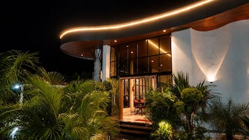 Um edifício moderno com fachada curva, janelas amplas e entrada bem iluminada.