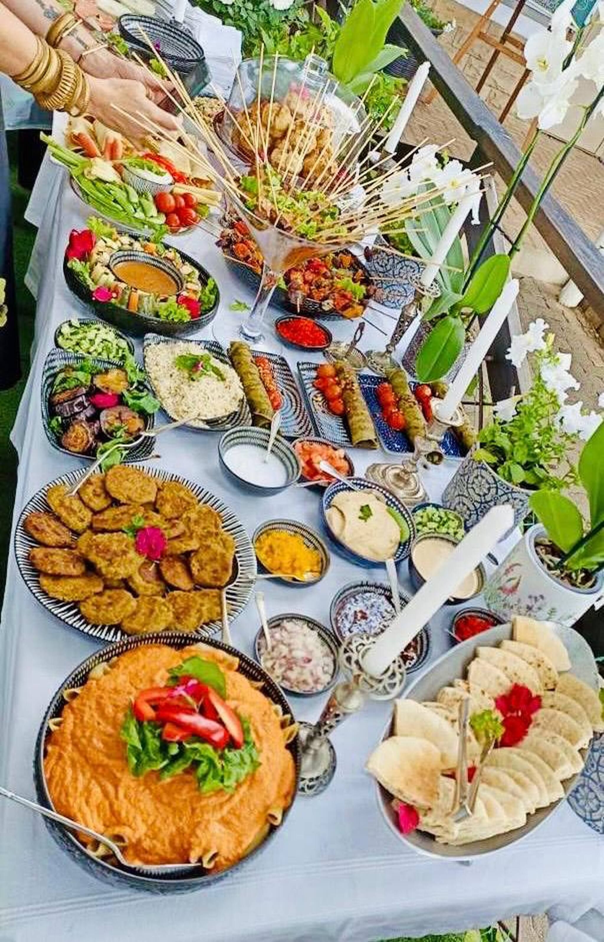 Uma mesa com diversos pratos, incluindo uma tigela grande de sopa, porções de comida e várias pequenas tigelas de acompanhamentos.