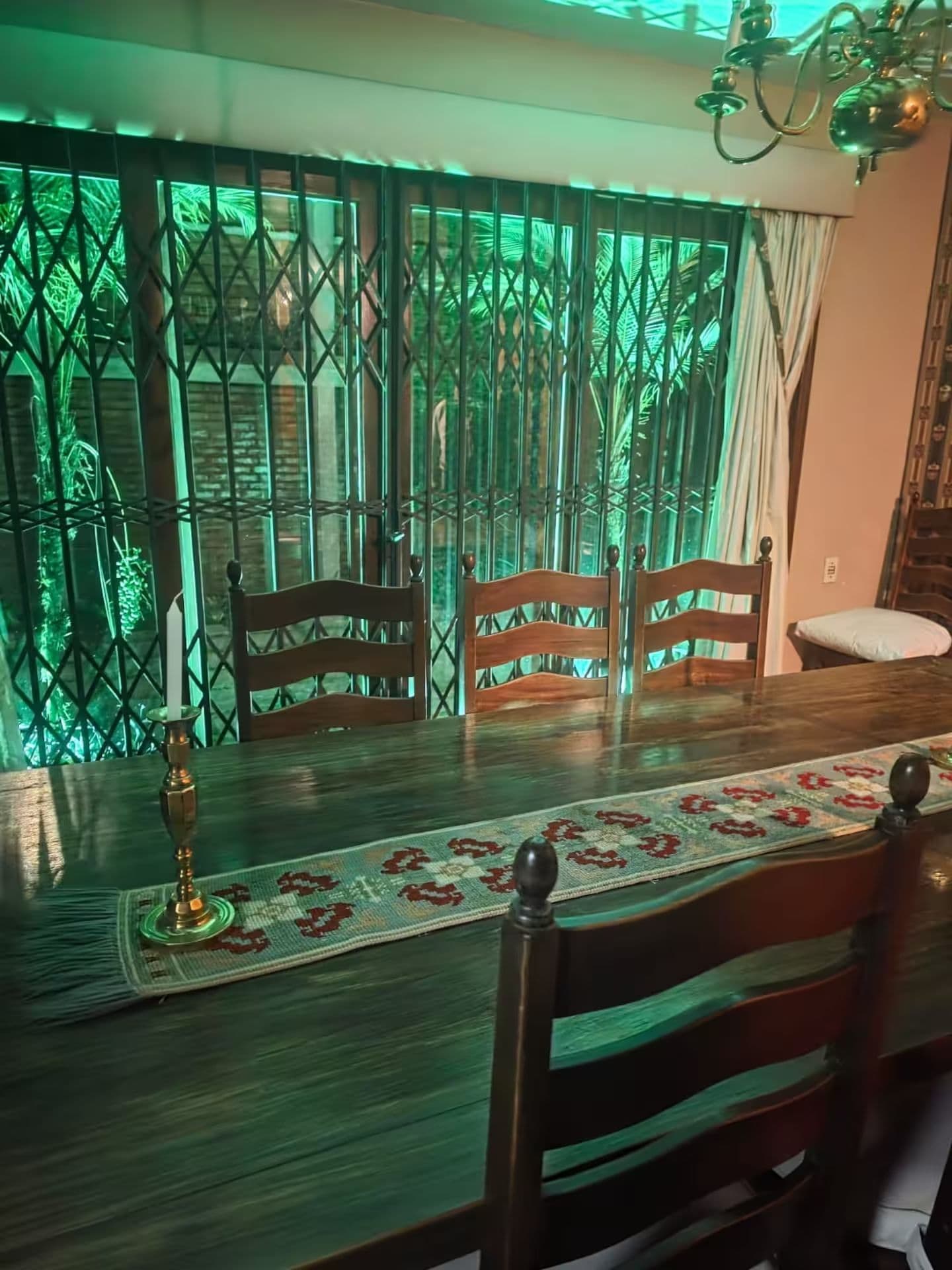 Uma sala de jantar com mesa, cadeiras e um tapete decorativo.