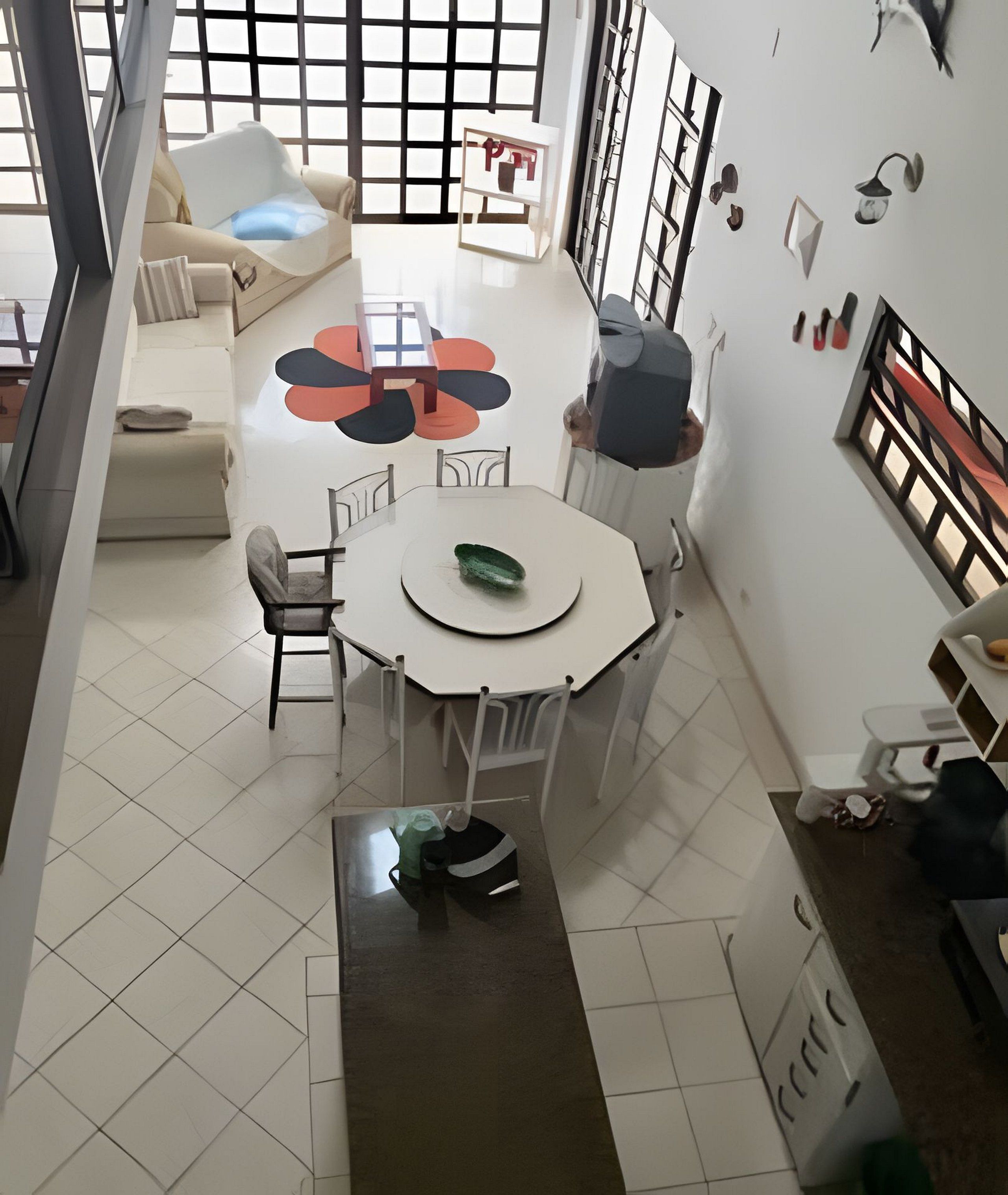 Uma sala de estar moderna com um sofá, uma mesa de jantar com cadeiras e uma área de cozinha com fogão.