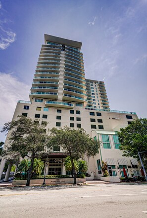 Hotel moderno com vários andares, design contemporâneo, com varandas e entrada destacada.